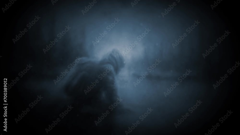 Scary man sits bending over by water. Human's figure in raincoat with ...