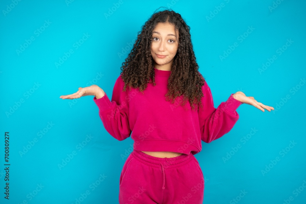 Clueless beautiful teen girl shrugs shoulders with hesitation, faces ...