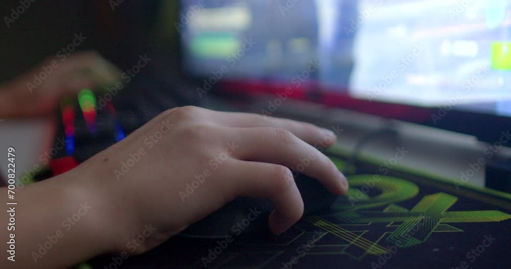 Close-up view of children's fingers interact with computer keyboard and computer mouse due to ...