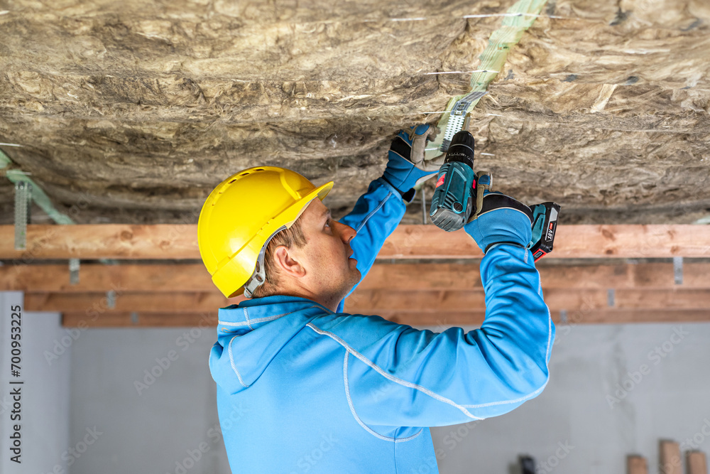 Lowering and insulate the ceiling. Fixing a suspend sheet to the load ...