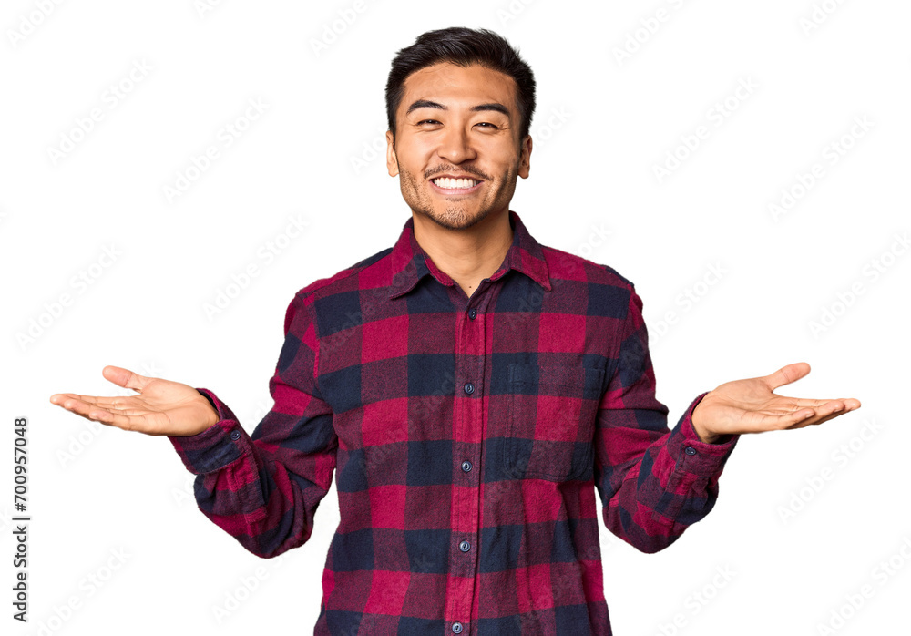Young Chinese man in studio background makes scale with arms, feels ...