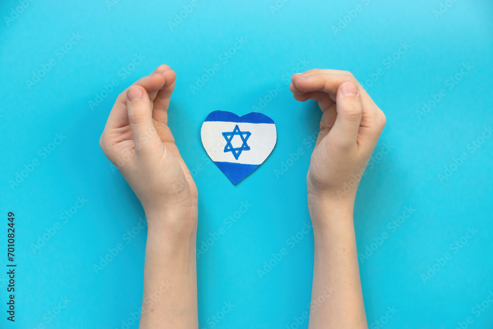 child's hands and a drawn Israeli flag in the shape of a heart on a ...