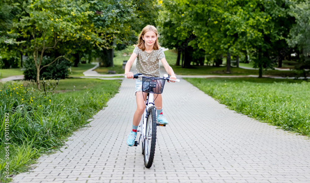 Cute preteen girl riding bycicle outdoors and smiling in beautiful ...