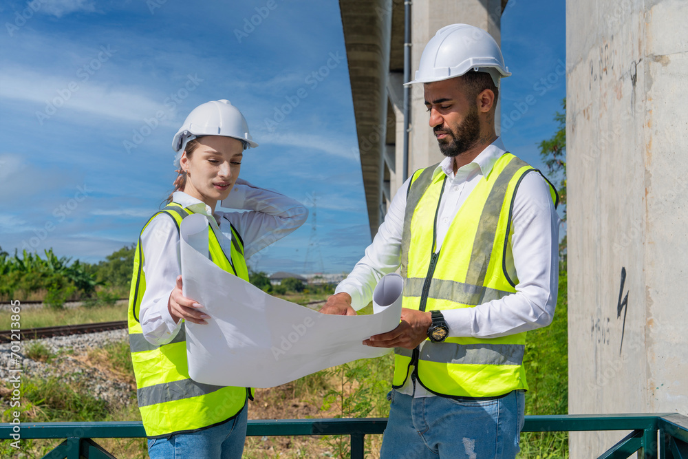 Caucasian female engineer and Middle Eastern male wearing uniforms and ...