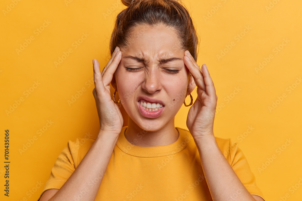 Exasperate young woman suffers from terrible headache keeps hands on ...
