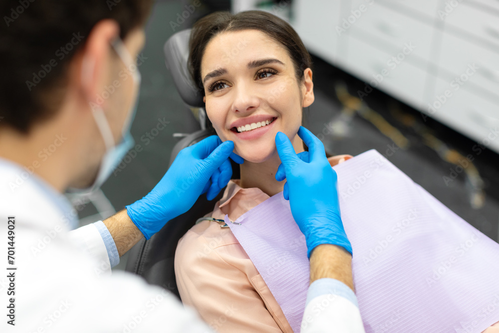Male dentist checking teeth of an attractive woman, doctor in rubber ...