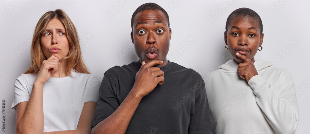 Horizontal shot of thoughtful European woman holds chin concentrated ...