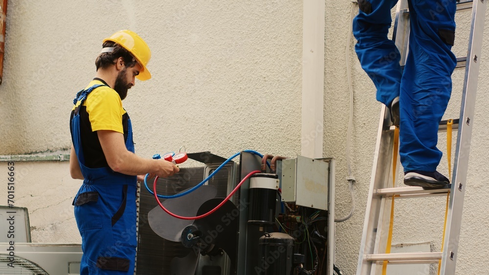 Expert mechanic measuring refrigerant levels in air conditioner with ...
