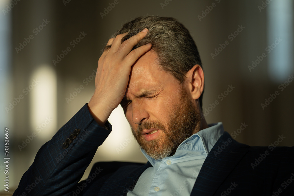 Tired man suffering from headache, touching head, relieving pain ...
