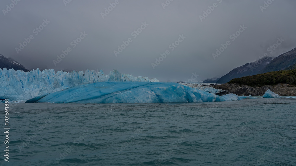 The famous Perito Moreno Glacier. A wall of blue ice against a cloudy ...