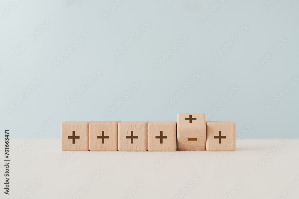 Plus sign on wooden cube block with one flipped minus to plus. Addition ...