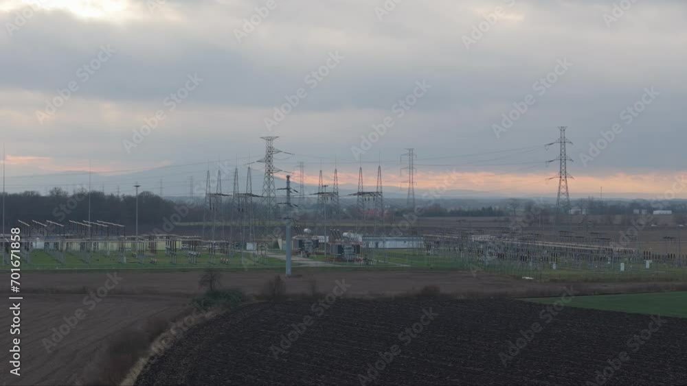 Aerial and ground-level footage of a transformer station set against a ...