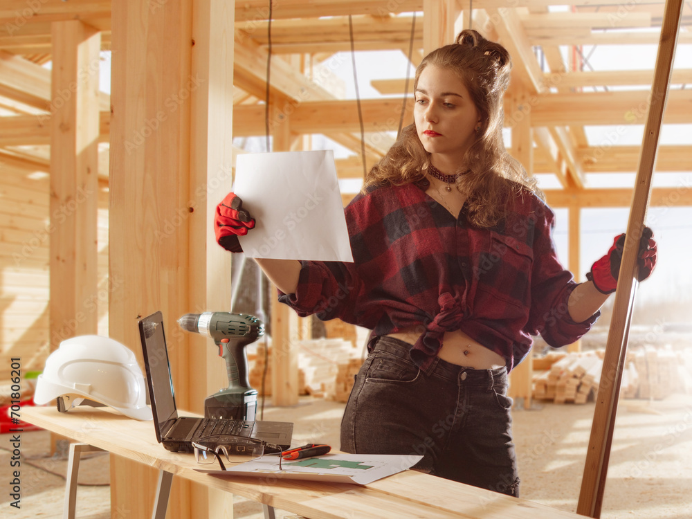 Woman carpenter. Girl carpenter at construction site. Builder holds ...