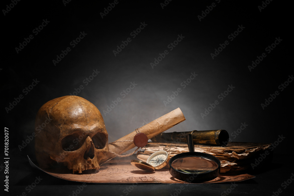 Human skull with old manuscripts, travel equipment and world map on ...