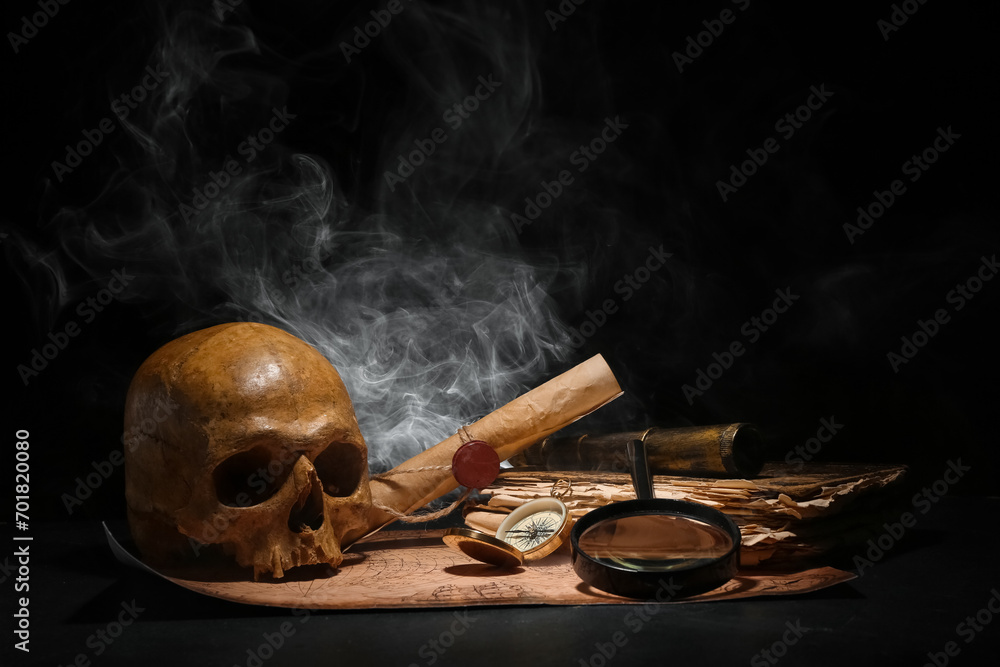 Human skull with old manuscripts, travel equipment and world map on ...
