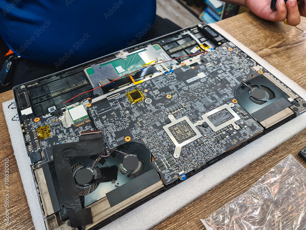 Computer technician disassembling mainboard with circuit of laptop ...