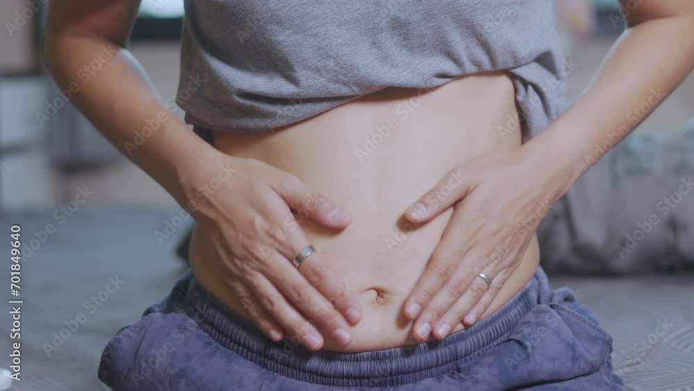 Close-up shot of her hand touching and shaking her fat belly and ...