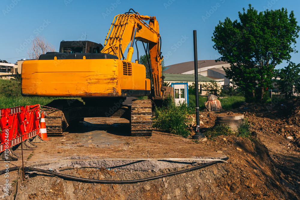 an open pit with a loader for laying pipes. a paved road to improve ...