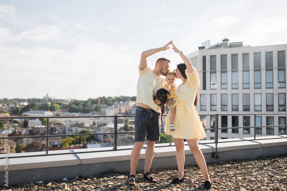 Good-looking man and woman imitating home with their hands and kissing ...