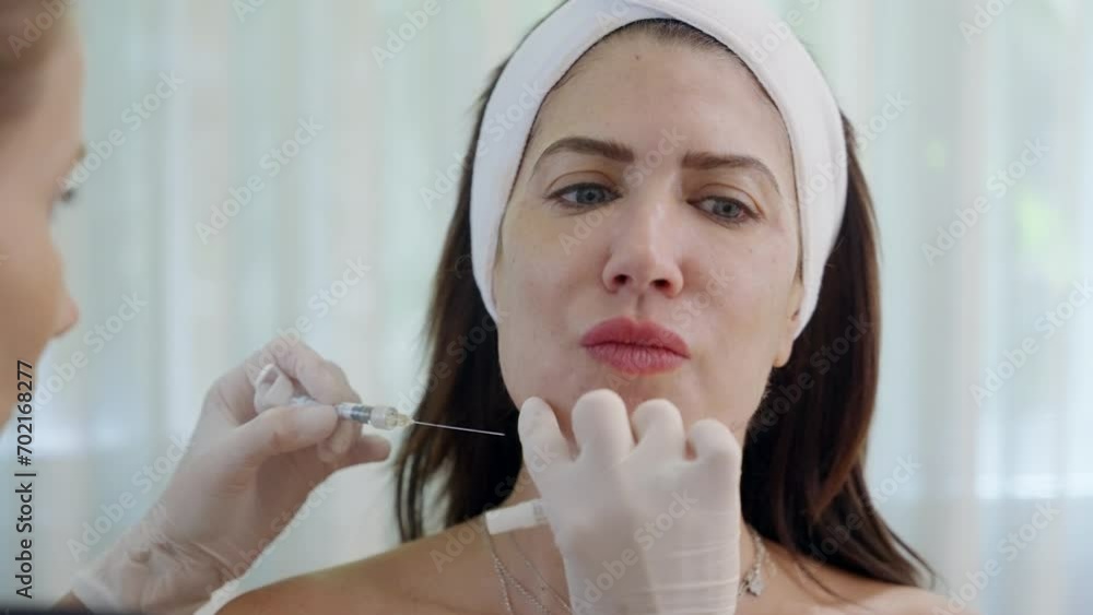 A Beautician doctor makes a botox injection in the cheekbone of a young ...