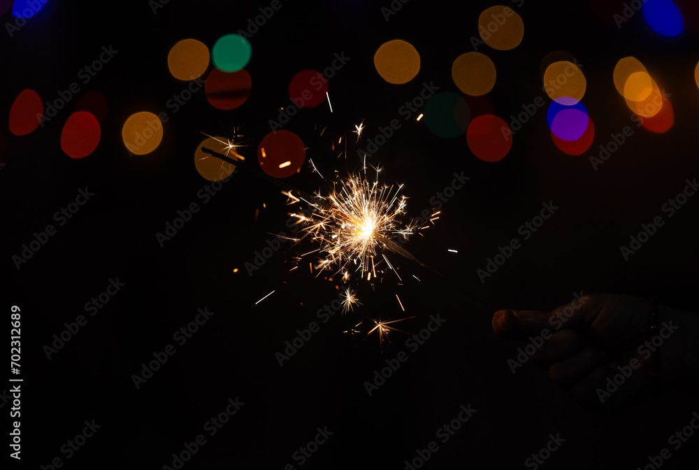 Sparkler or Fuljhadi in hand with dark black background with colorful ...