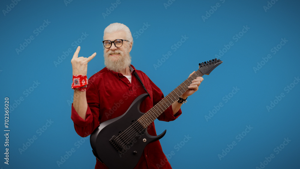Man in his 60s displays the heavy metal and hard rock horns hand ...