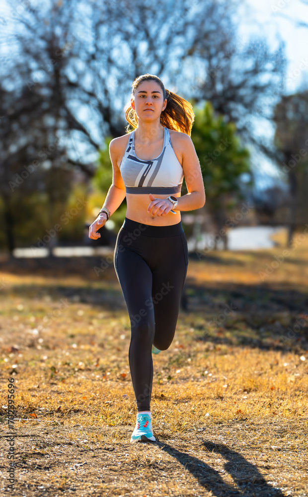 Beautiful young runner, dressed in tight sportswear and top, running ...