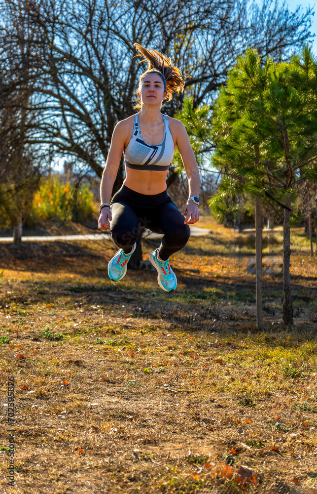 Young runner girl dressed in tight sports clothing and top, suspended ...