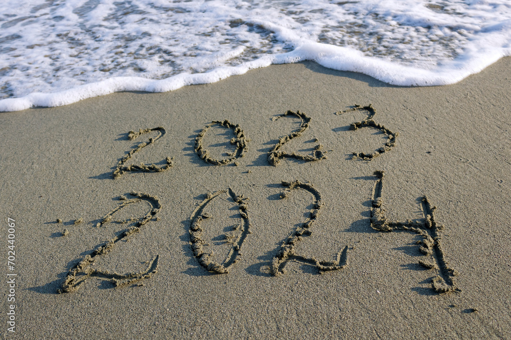 Numbers 2023 and 2024 written on beach sand Stock Photo | Adobe Stock