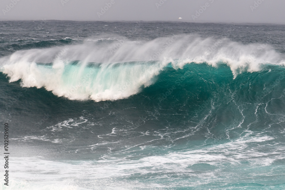 An angry turquoise green colour massive rip curl of a wave as it rolls ...