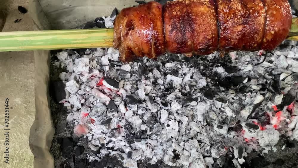 Grilling lechon belly in the traditional way. Whole piece of pork on a ...