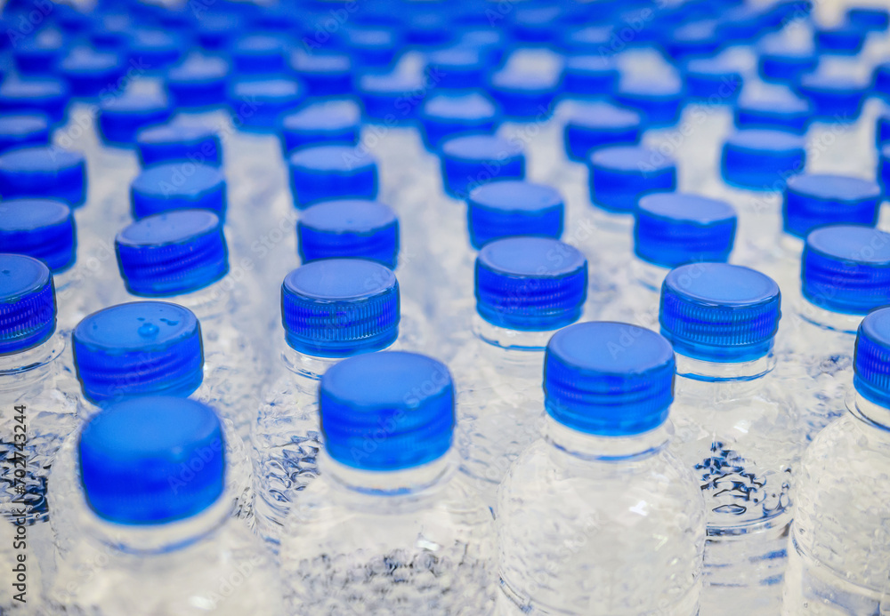 Many blue drinking water bottle caps and pure drinking water bottles in ...