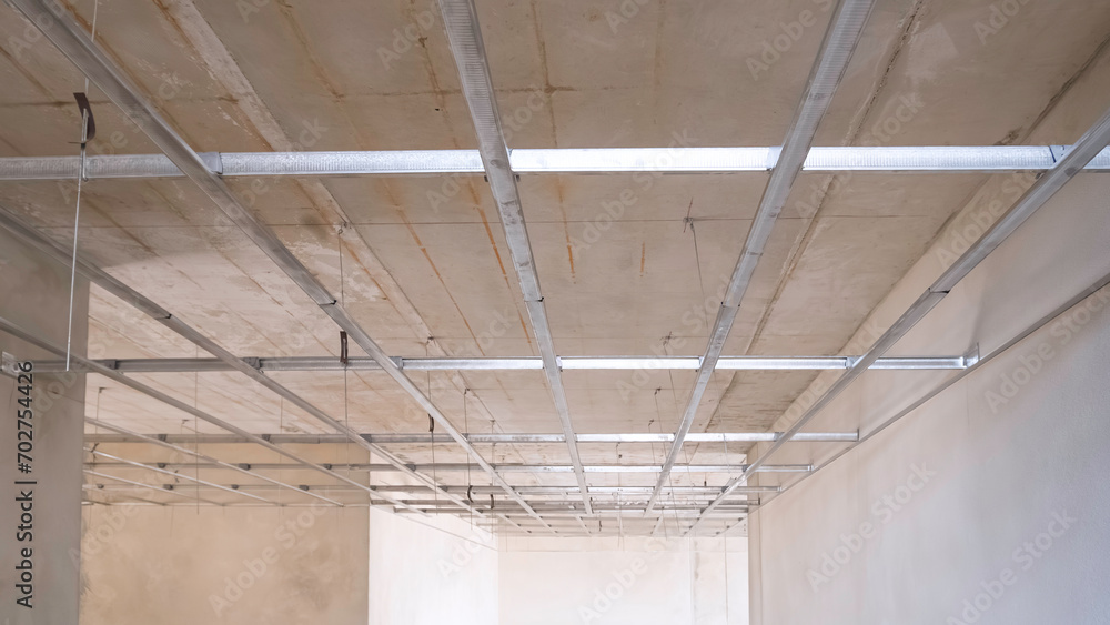 Aluminum c-line ceiling outline on concrete wall over corridor inside ...