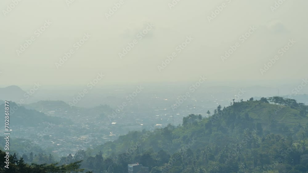 A panning view of cities and hills full of air pollution from vehicle ...