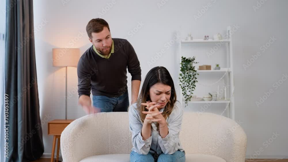 Hopeless young woman sitting on the sofa at home, while her husband ...