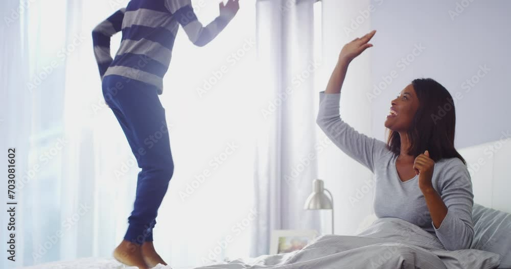 Family fun, jumping and bed with kid, mother and clapping in a bedroom ...