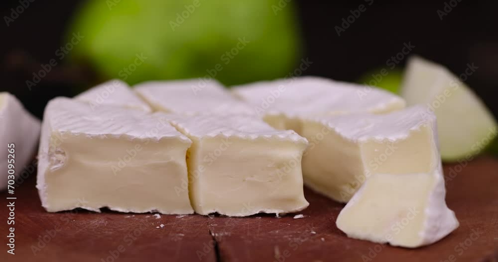 soft processed cheese with white mold on the table, sliced white cheese ...