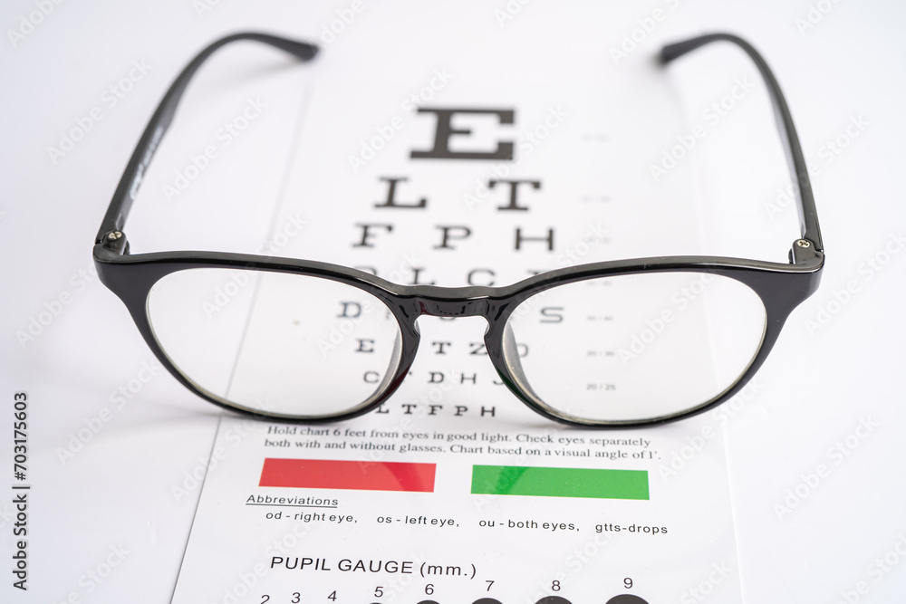Glasses on eye testing exam chart to check eyesight accuracy of reading ...