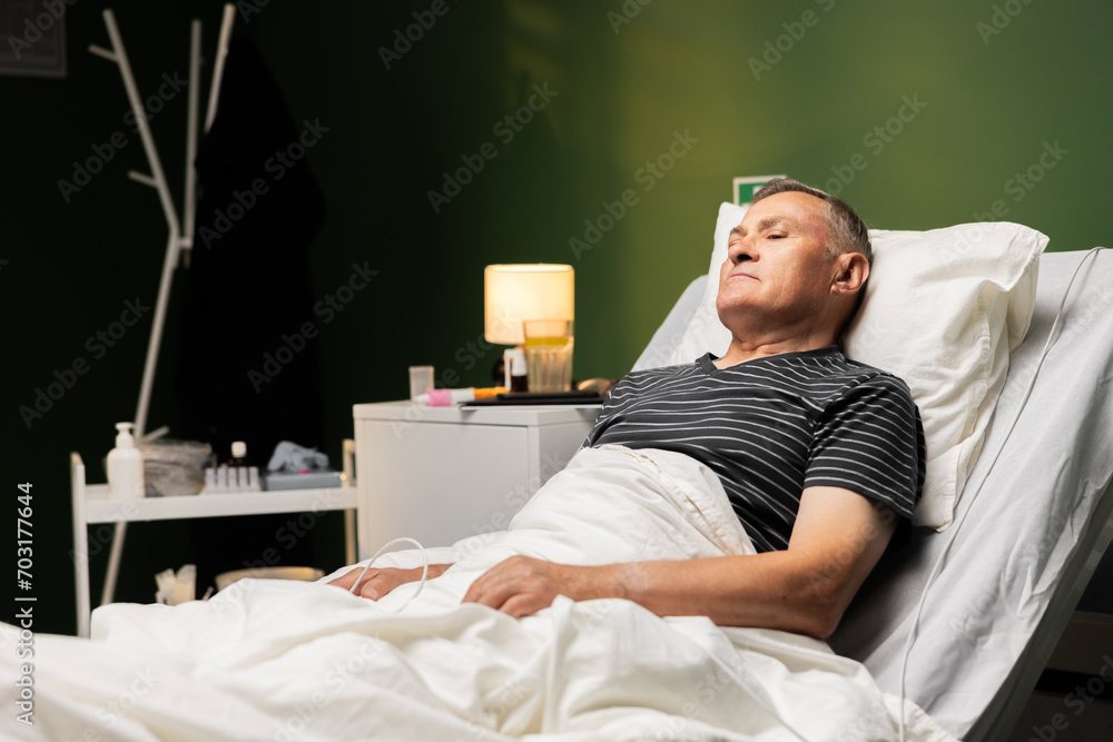 An elderly man lies in a hospital bed gathering strength for a speedy ...