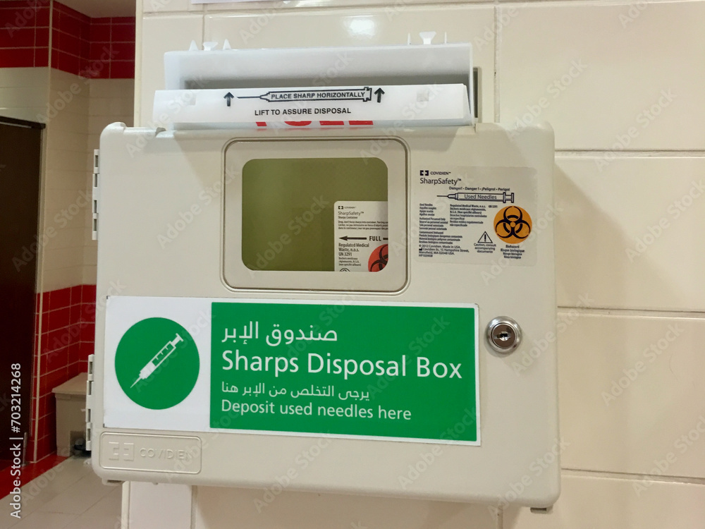 Safe medical needle disposal container on a toilet wall in the Dubai ...