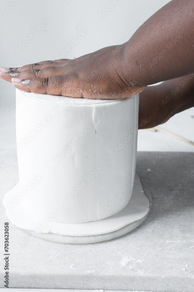 Covering a cake with fondant, paneling a Styrofoam cake dummy with ...
