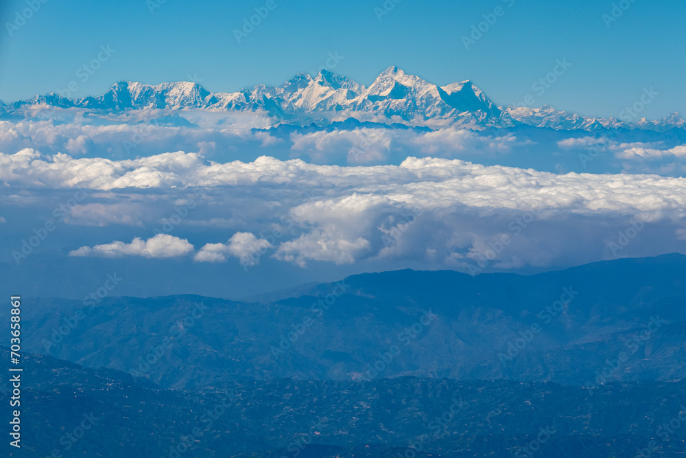 Aerial view of dusky layers of blue, green, and snow-capped mountain ...