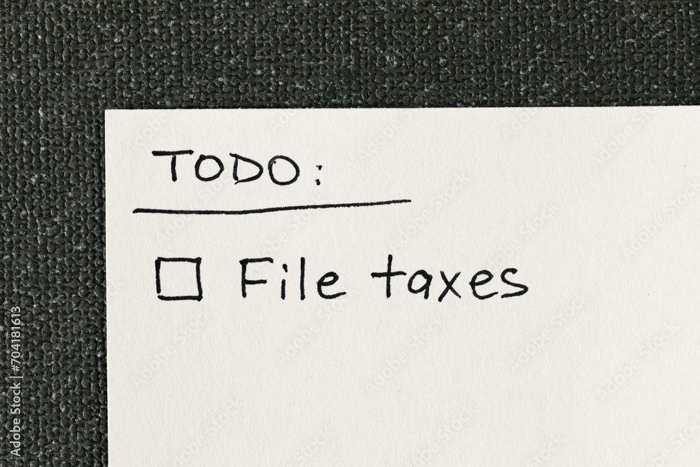 Handwritten to-do list with 'File taxes' reminder and a checkbox ...