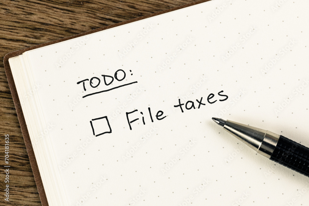 To-do list with 'File taxes' checkbox reminder handwritten on an open ...