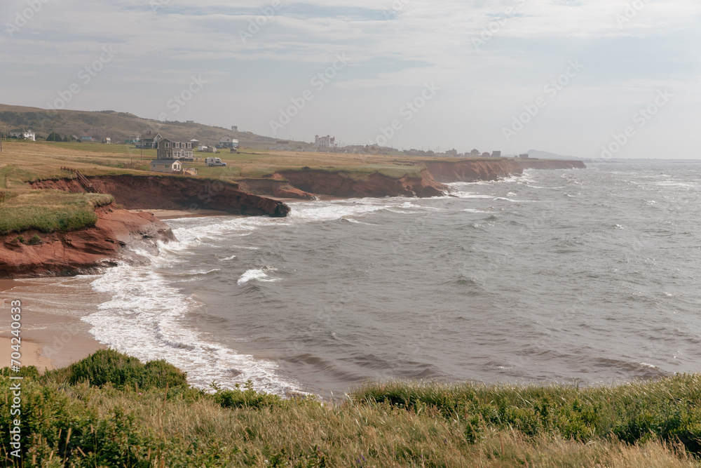 vue sur une baie avec des vagues au bord de falaises de roche rouge et ...