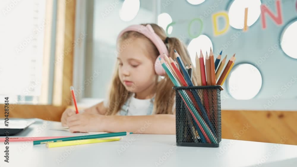 Cute girl doing classwork or online learning while listen to teacher ...