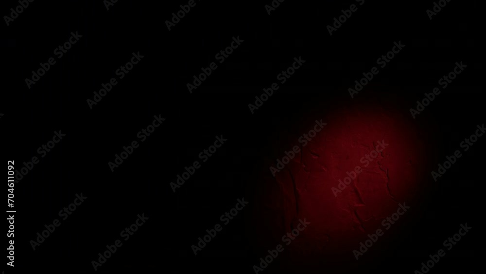 Cinematic red spot of light on a wall, disappearing into the darkness ...