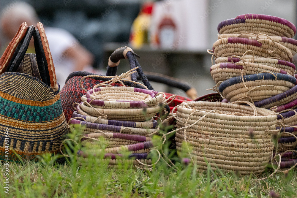Multiple stacks of different straw hand-weaved baskets with colorful ...