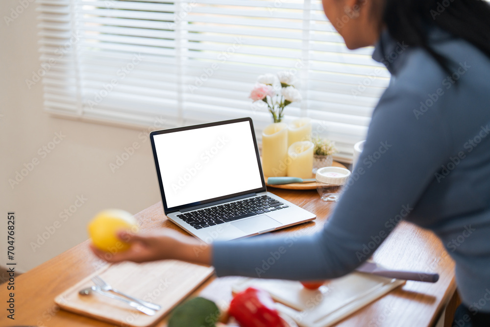 Cheerful Fat woman cooking in kitchen showing laptop mock up blank ...