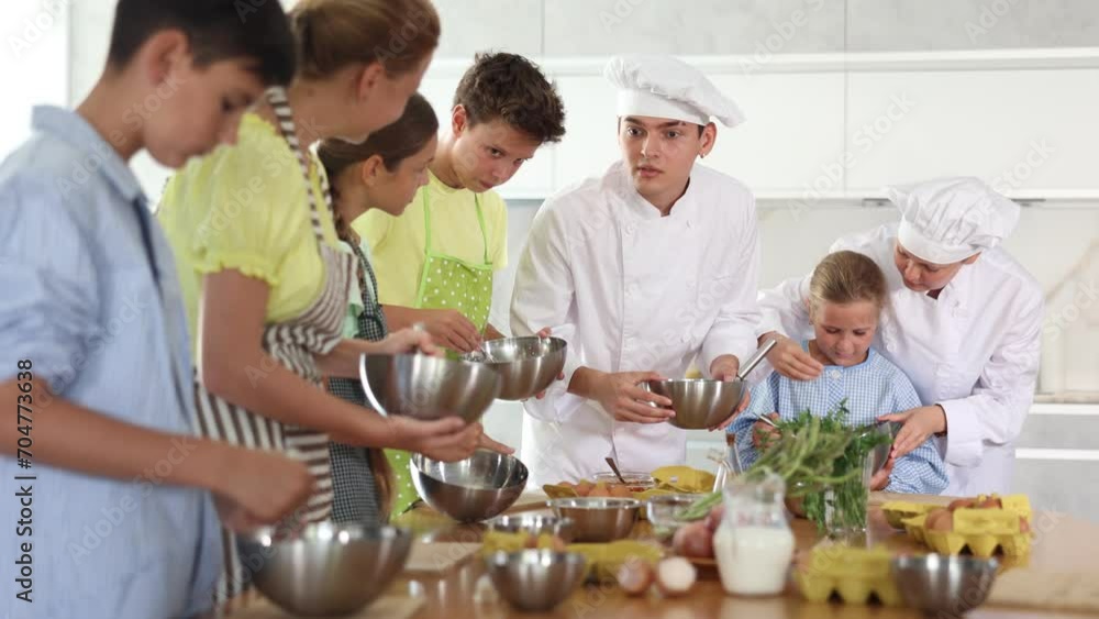 Amiable woman and young man, skilled chefs wearing white cook jackets ...